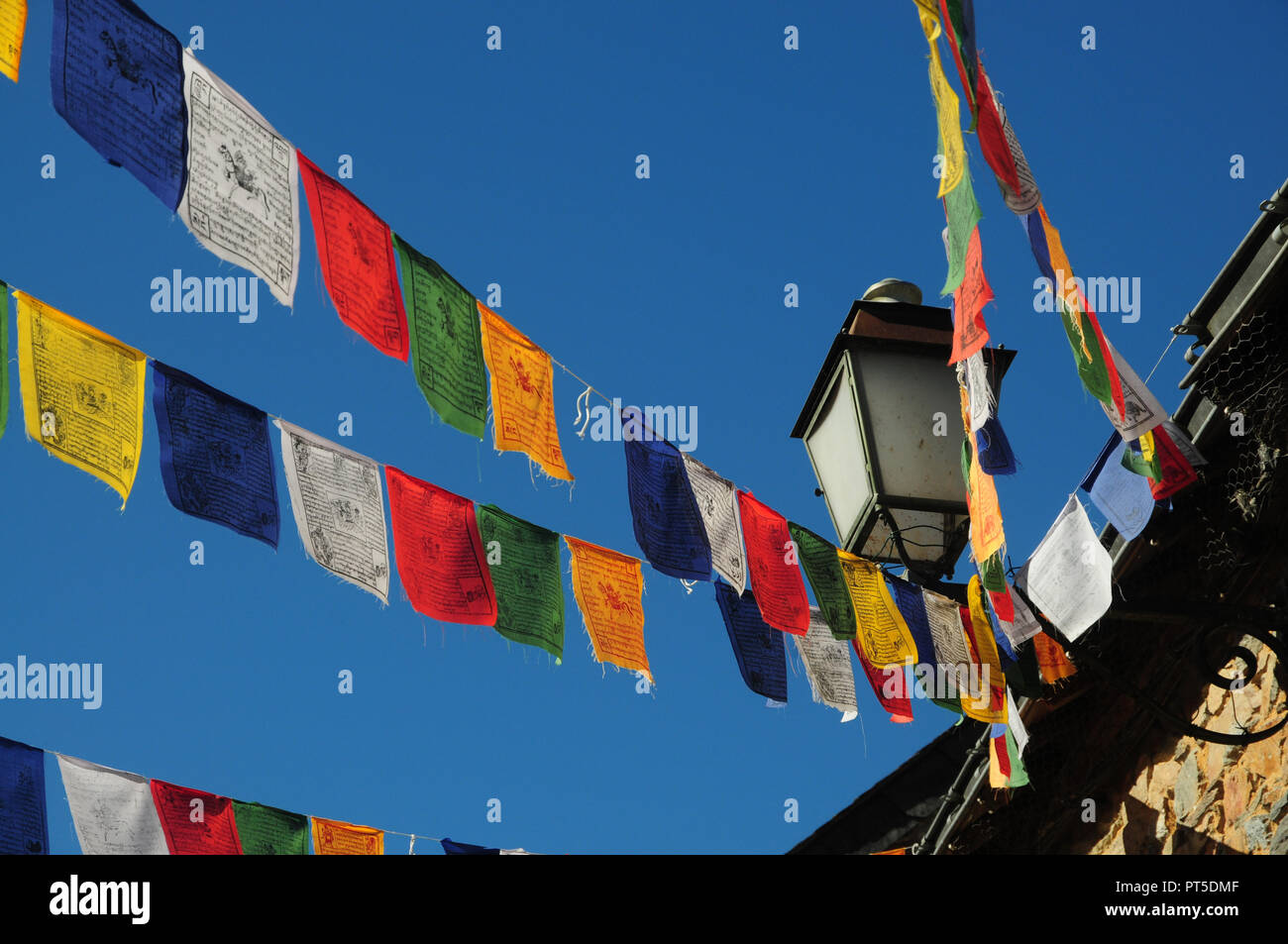 Tibetan Buddhist prayer flags fluttering against a blue sky in La ...