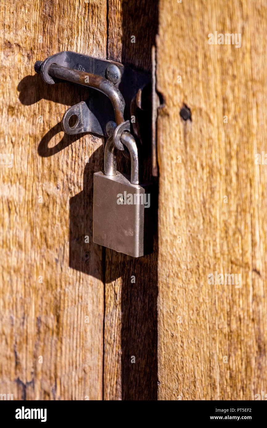 The door to this old wooden building is bolted shut and locked with a ...