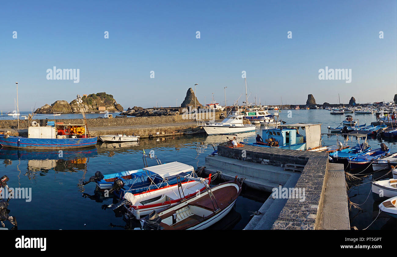 Sunset at the harbour of fishing village Aci Trezza, behind the cyclops ...