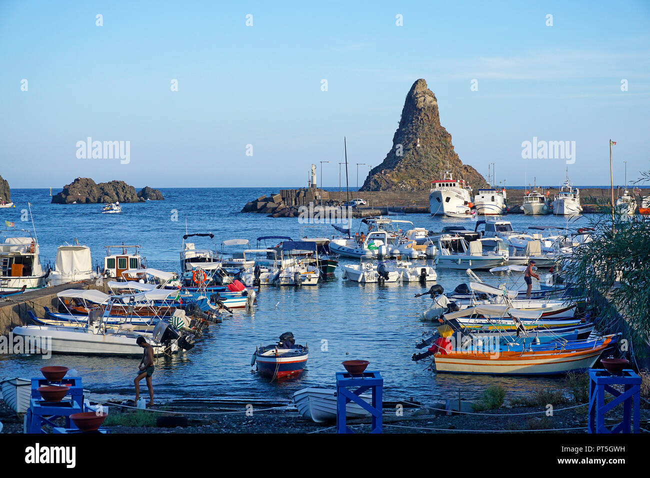 Fishing boats at harbour of Aci Trezza, behind the basalt rock ...