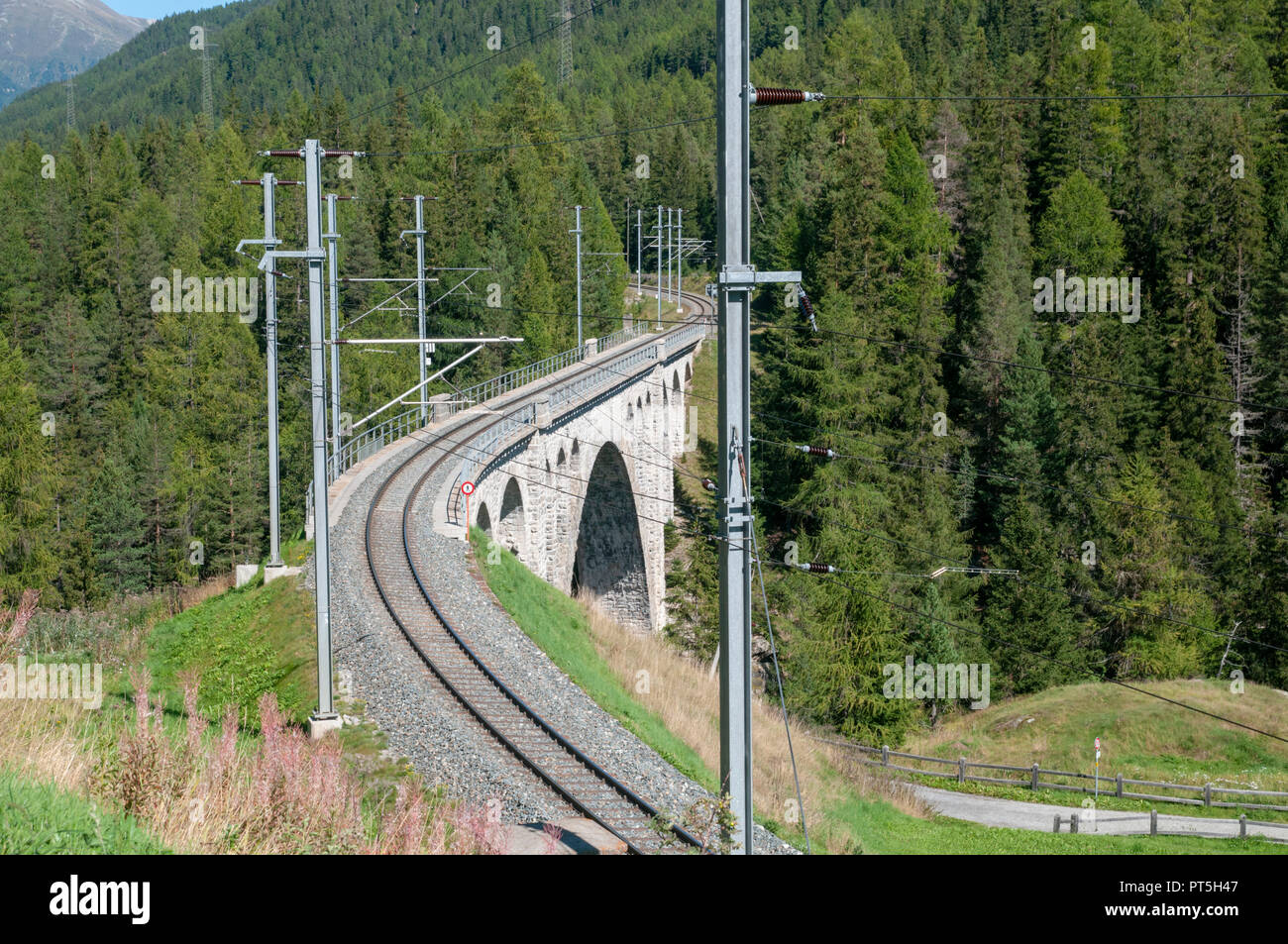 Railway tracks over a stone bridge, in the Swiss Alps near Brail in the ...