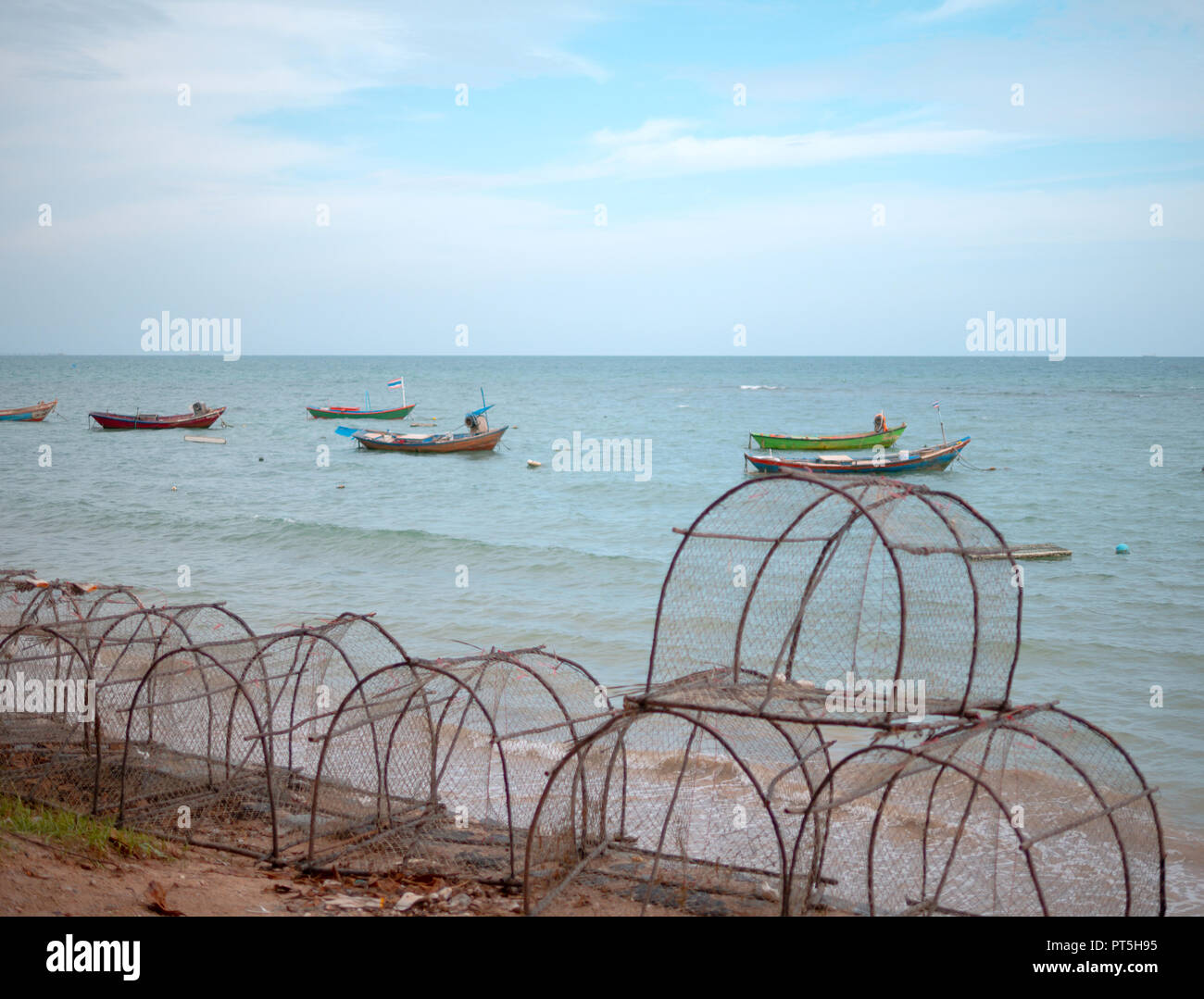 Fish Trap Device on the sea beach with group small fishing boat on the ...