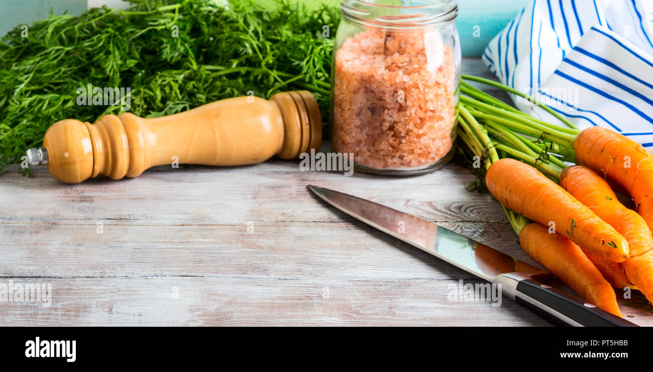 Raw carrots on rustic wooden background. Cooking vegetables Stock Photo ...