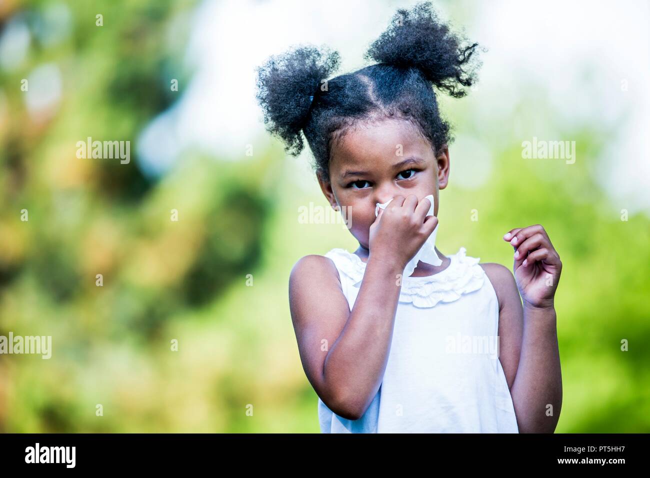 Girl using handkerchief while sneezing Stock Photo - Alamy