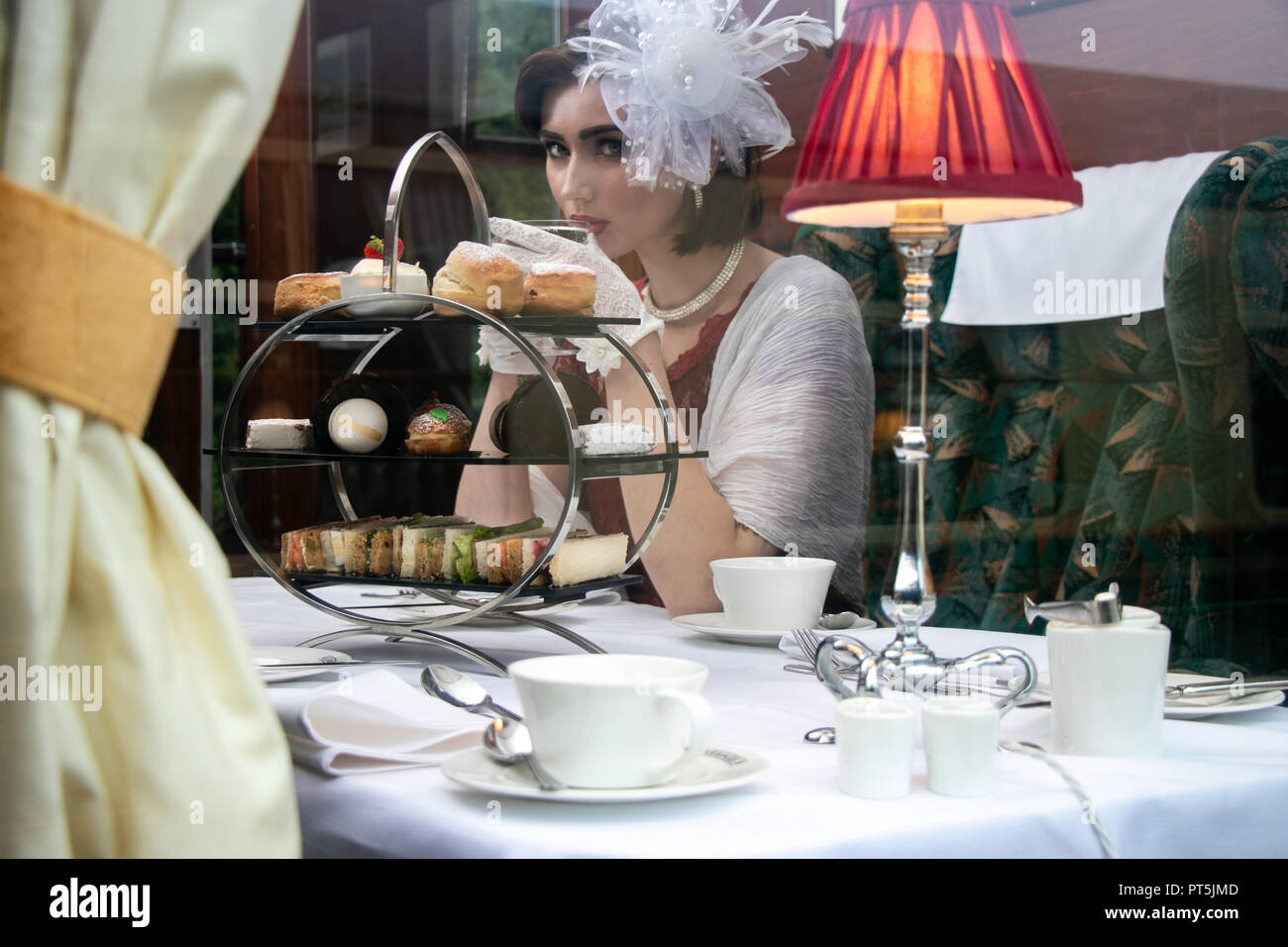 Vintage, beautiful woman in red afternoon tea dress enjoying afternoon ...