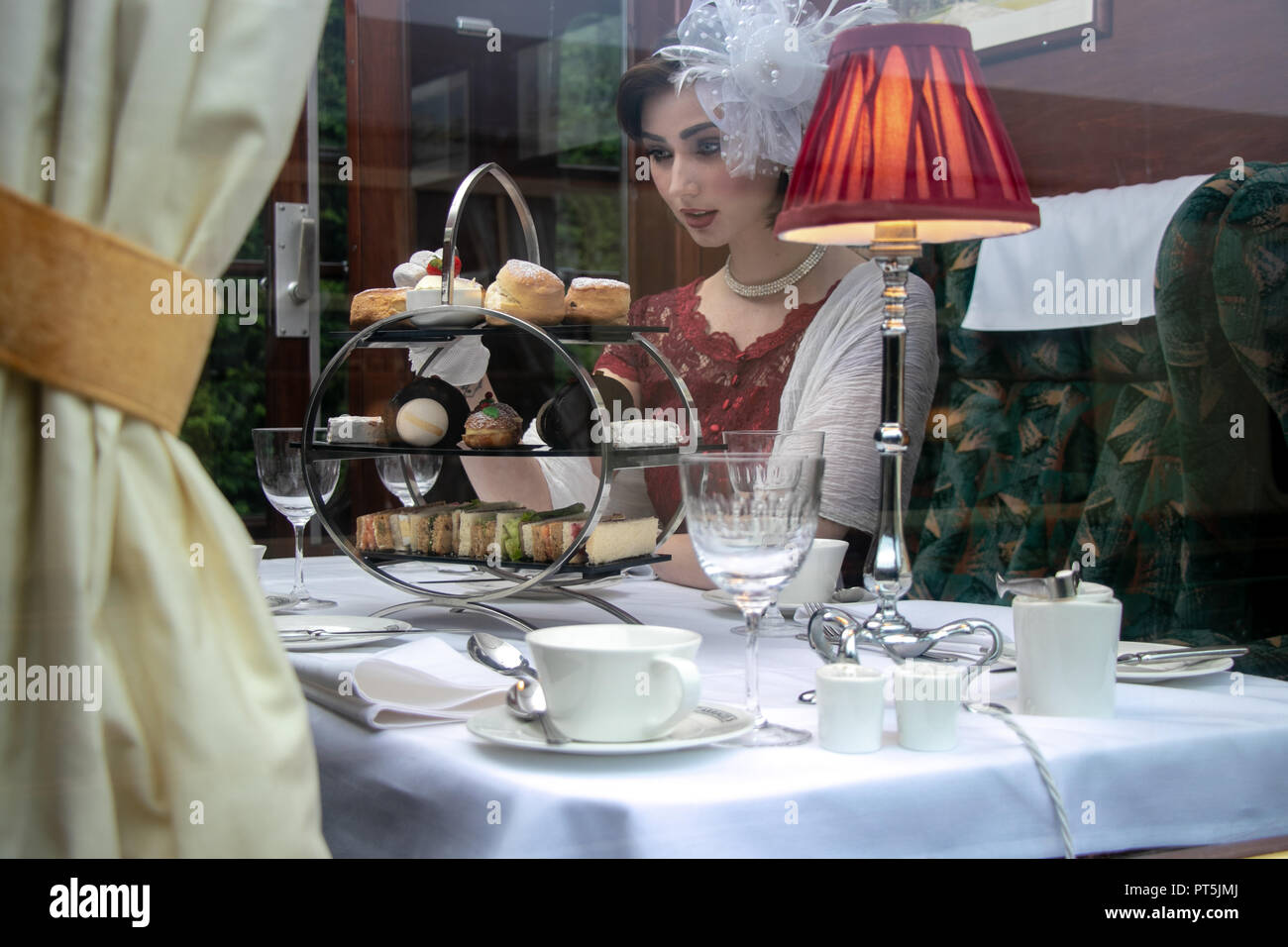 Vintage, beautiful woman in red afternoon tea dress enjoying afternoon ...
