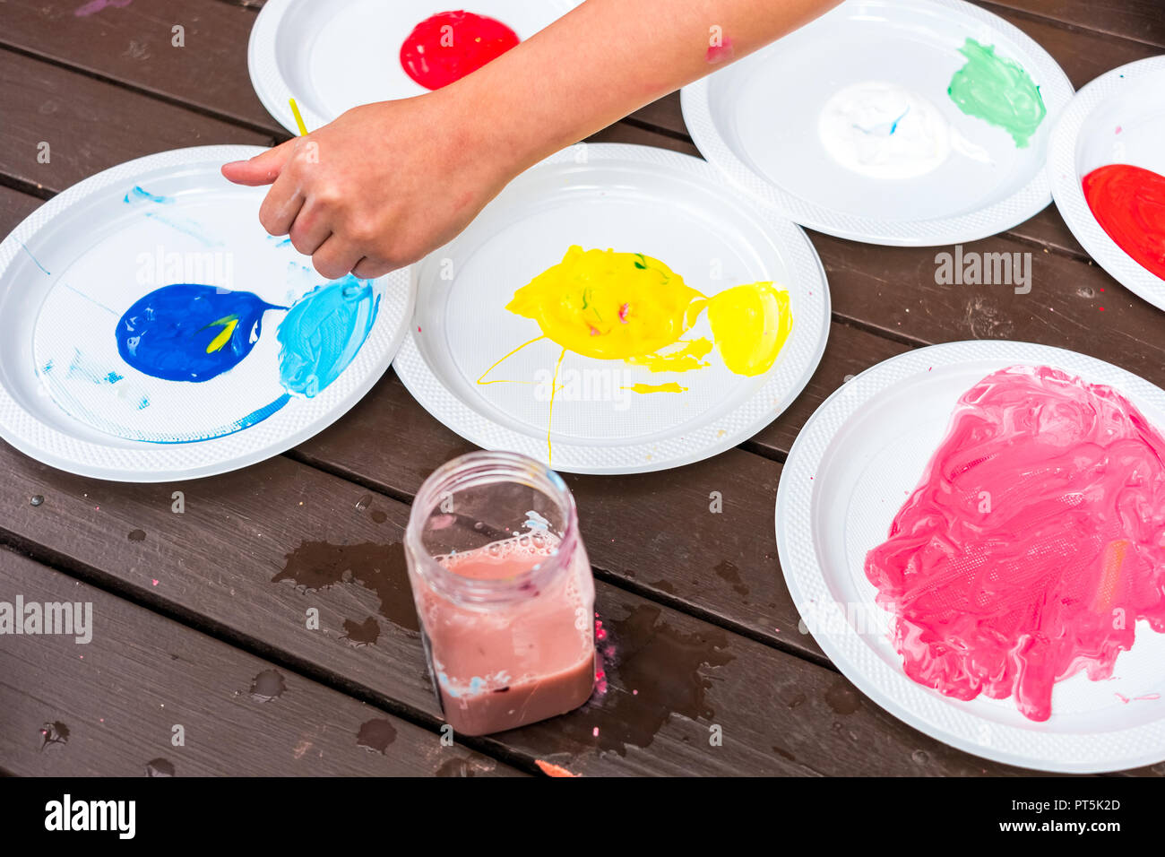 Child's hand picking color with brush from gouache paint set Stock ...