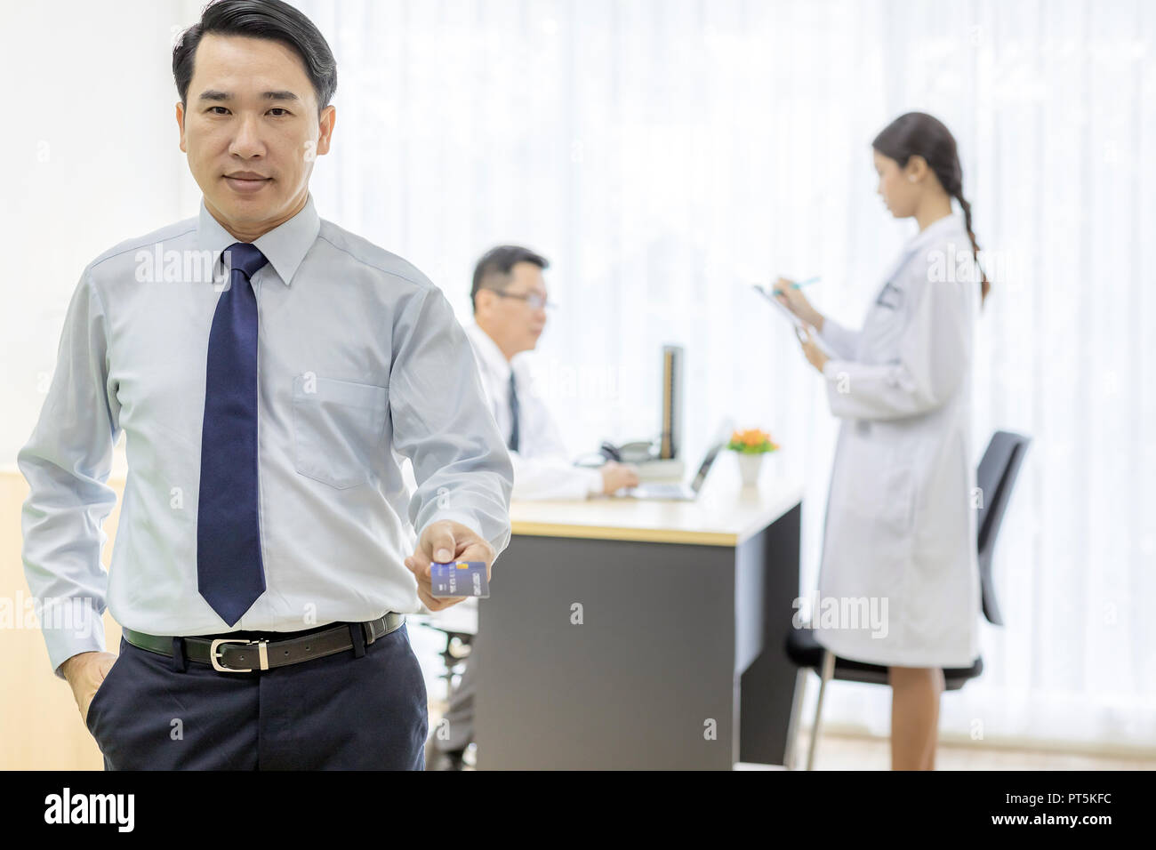 Portrait of Young adult Patient with credit card with examination room ...