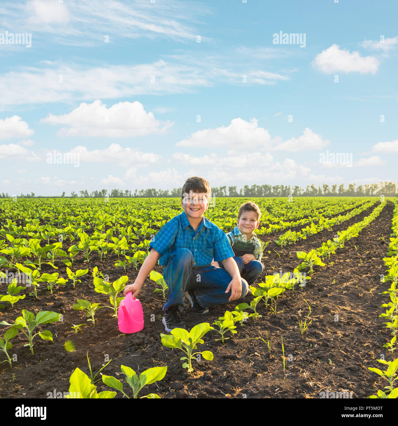 Happy small farmers in spring field Stock Photo - Alamy