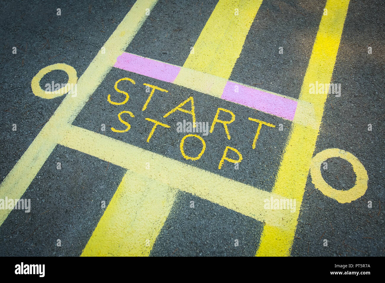 A start and stop sign marking race direction painted on paved road ...