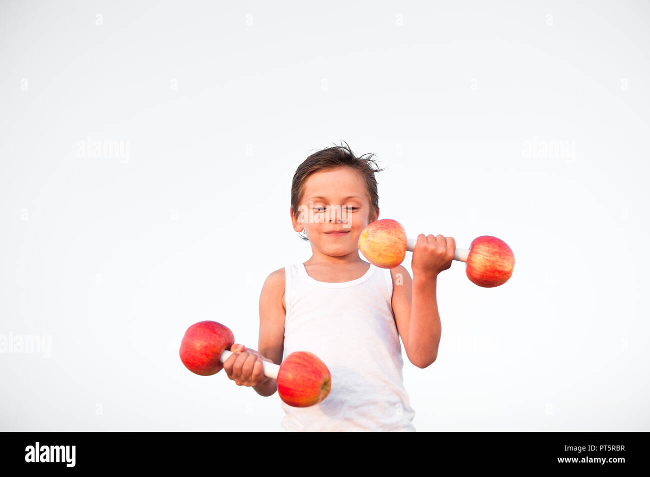 strong healthy cute caucasian kid in white shirt lifting dumbbells made ...