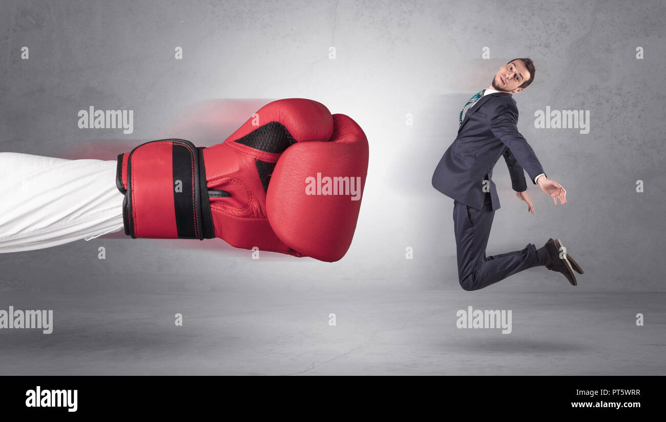 Businessman gets a hit from a giant hand with boxing gloves Stock Photo ...