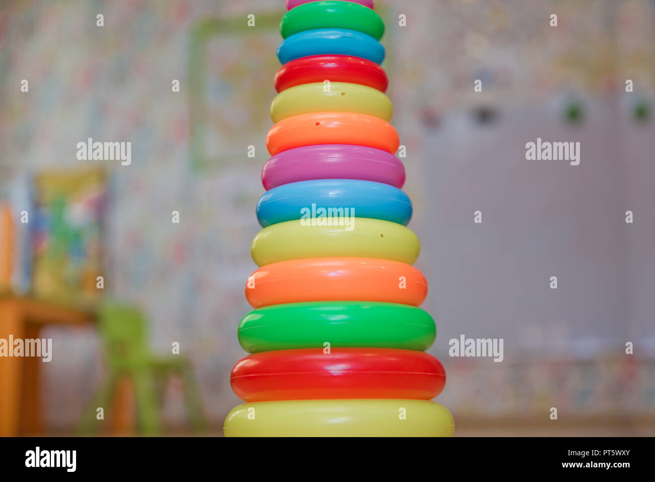 Children's plastic pyramid, composed of colored rings on yellow ...