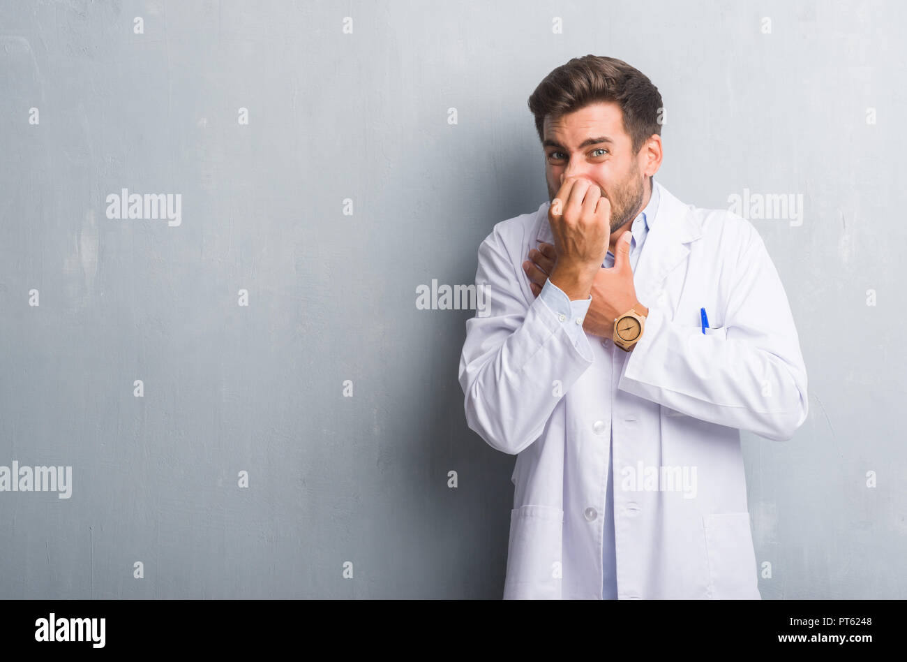 Handsome young professional man over grey grunge wall wearing white ...