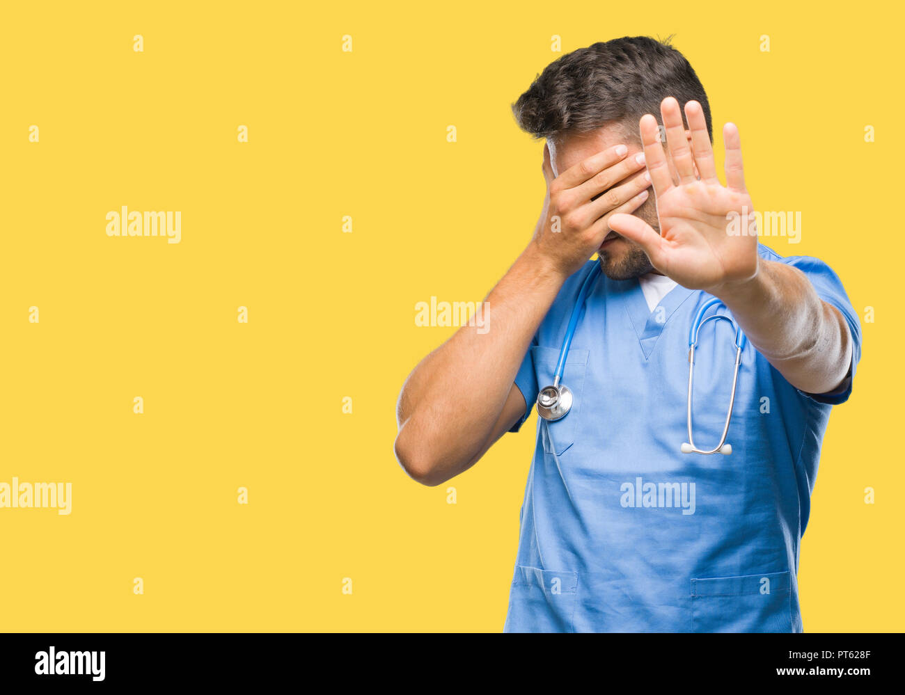 Young handsome doctor surgeon man over isolated background covering ...