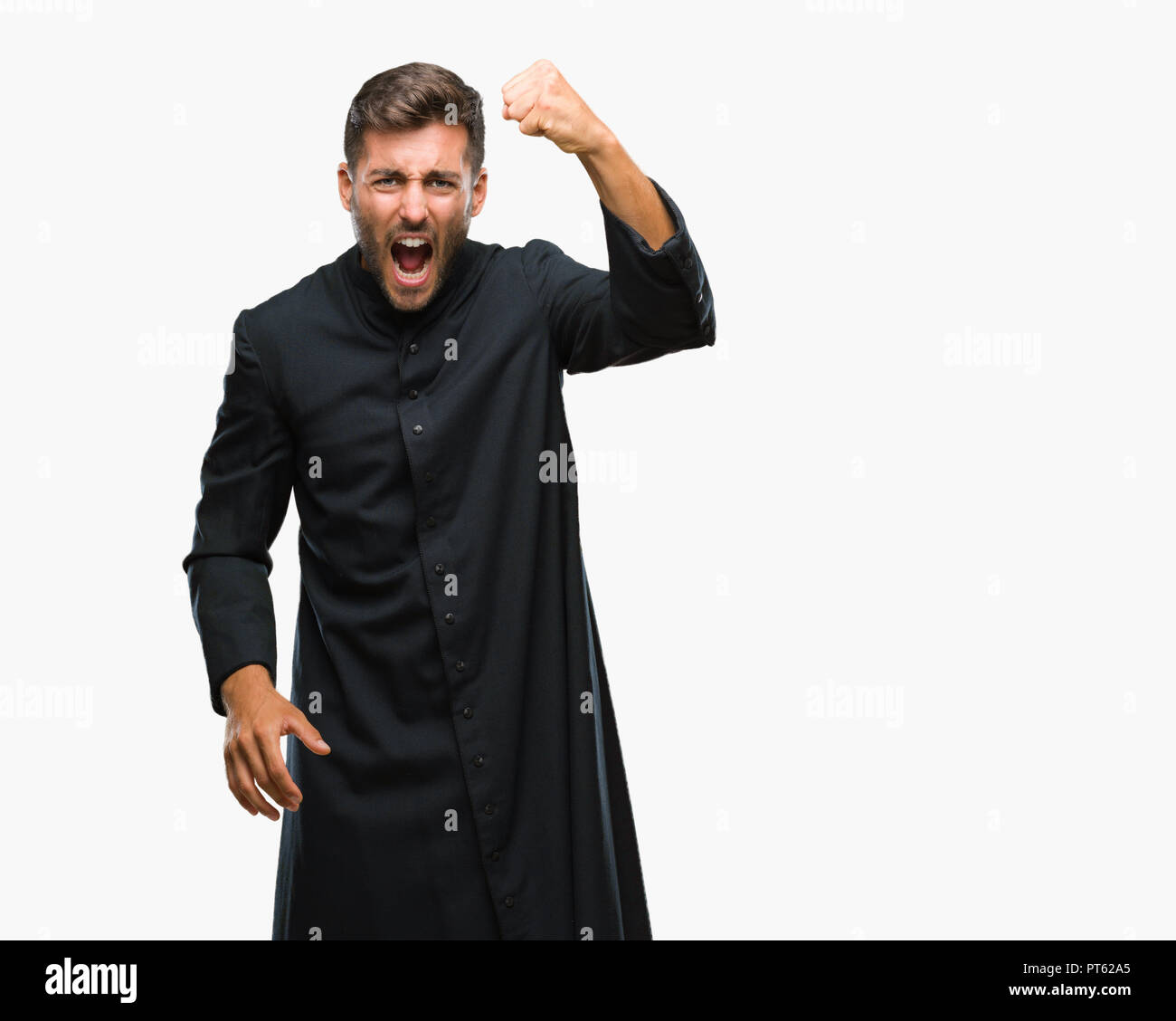 Young catholic christian priest man over isolated background angry and ...