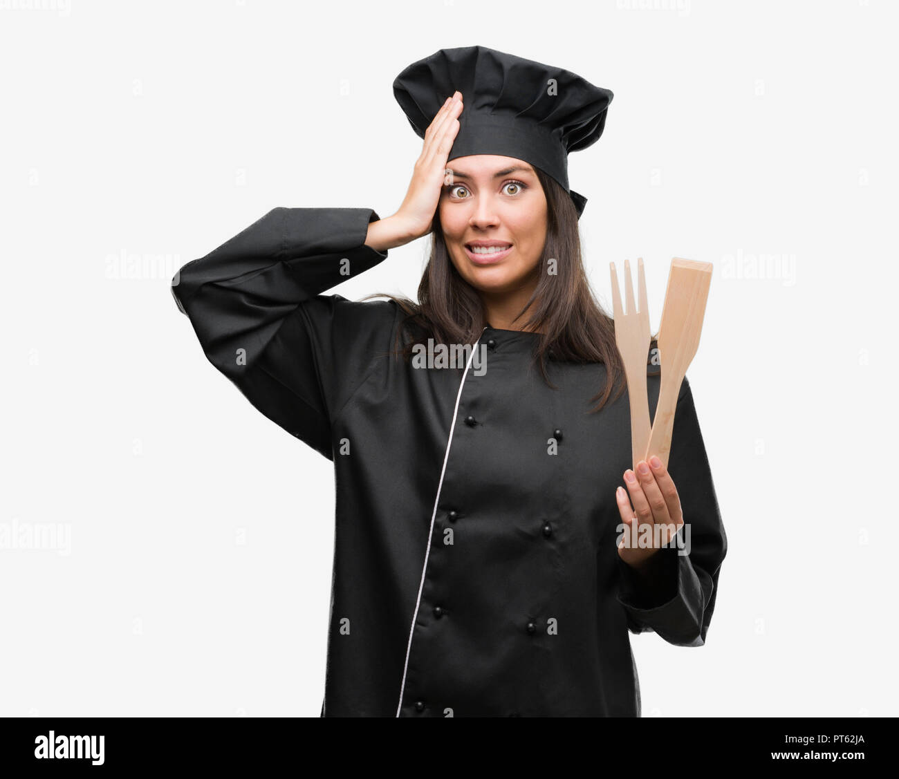 Young hispanic cook woman wearing chef uniform stressed with hand on ...