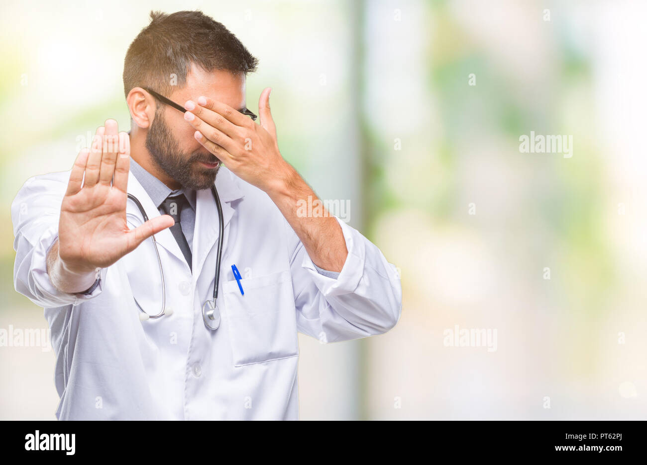 Adult hispanic doctor man over isolated background covering eyes with ...