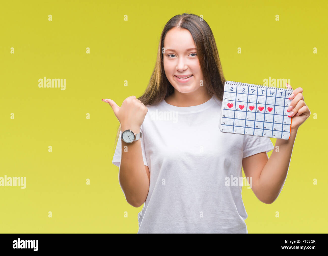 Young caucasian woman holding menstruation calendar over isolated ...