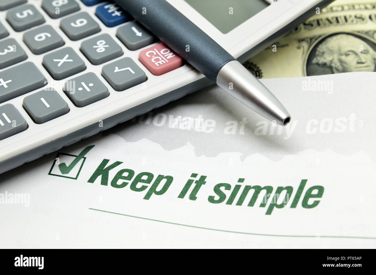 Keep it simple printed on book with calculator and pen Stock Photo - Alamy