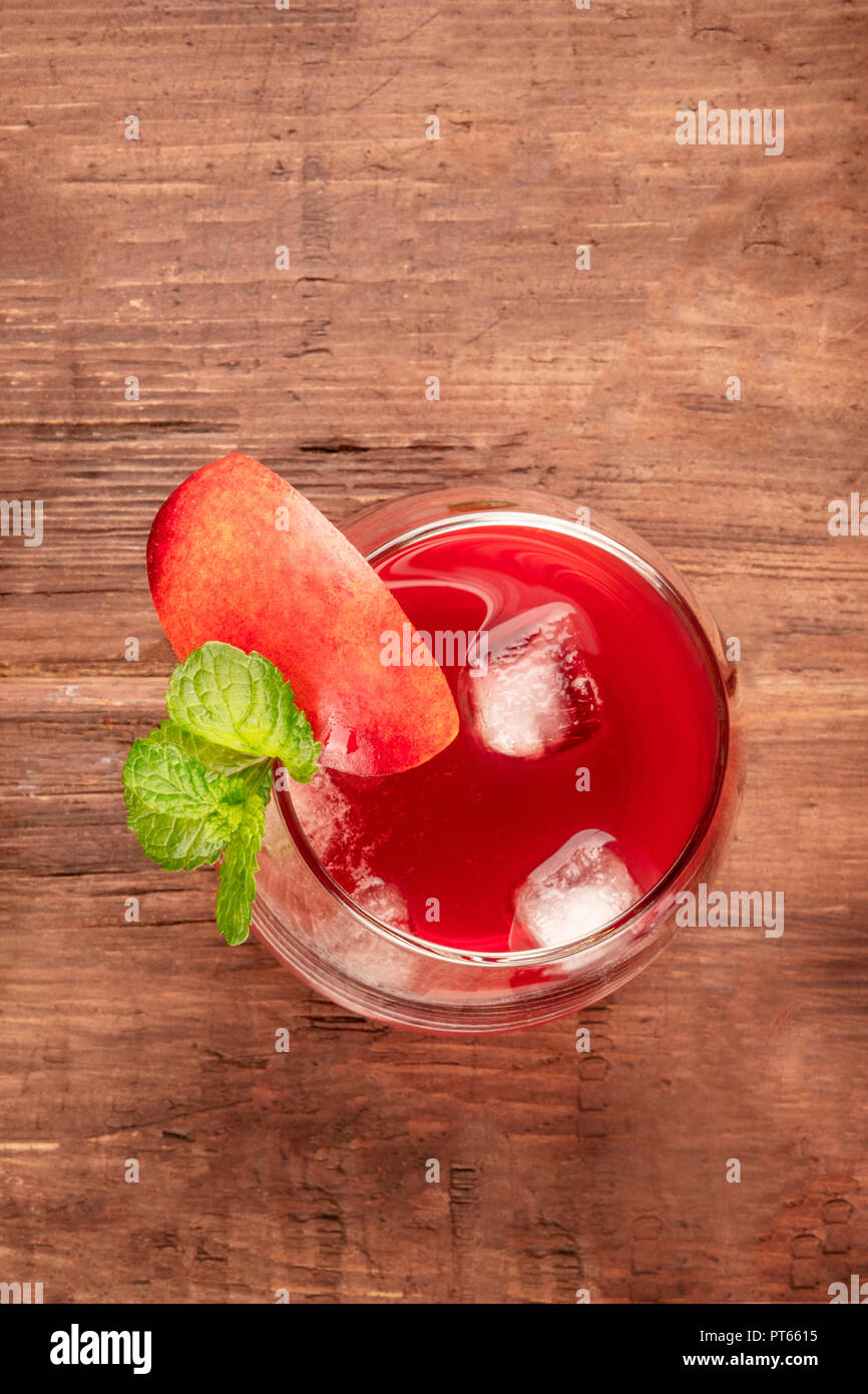 Overhead photo of vibrant red drink on dark a rustic background, with ...