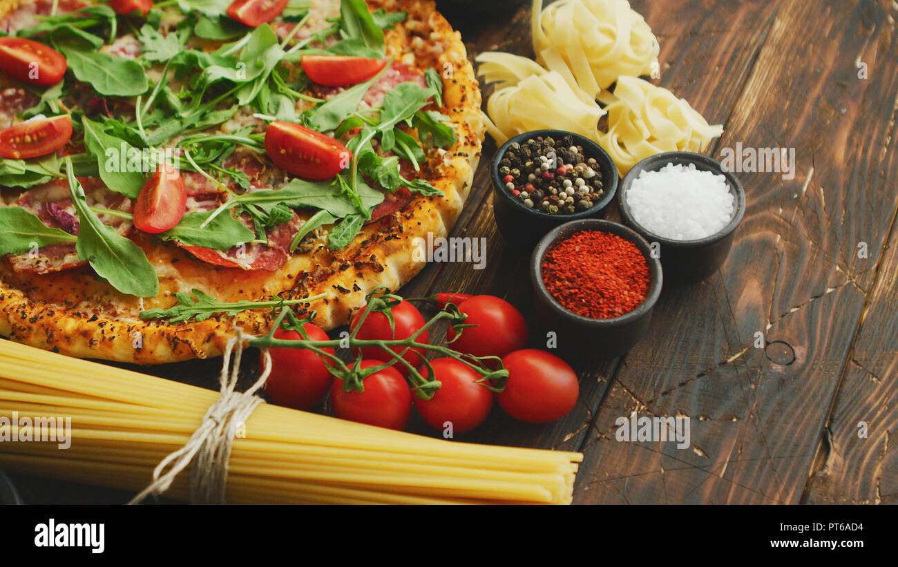 Italian food background with pizza, raw pasta and vegetables on wooden ...