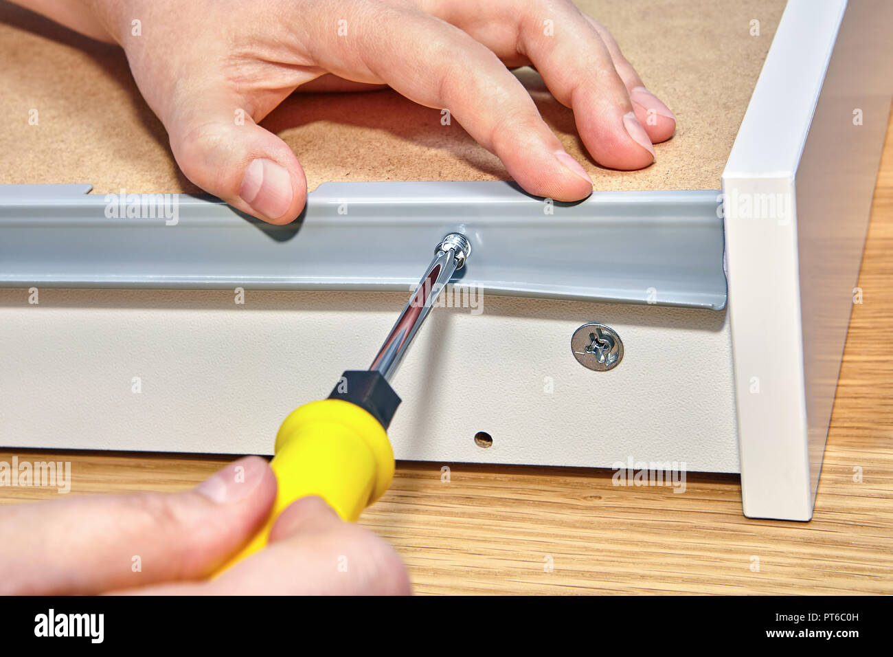 Installation furniture, screwing screw-bolt with using hand screwdriver ...