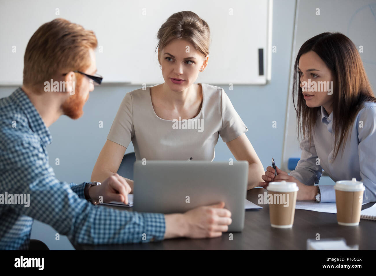 Serious focused business team discussing work results together i Stock ...