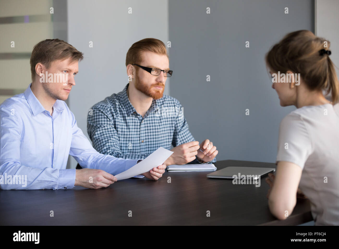 Serious male hr team listening female applicant at job interview Stock ...