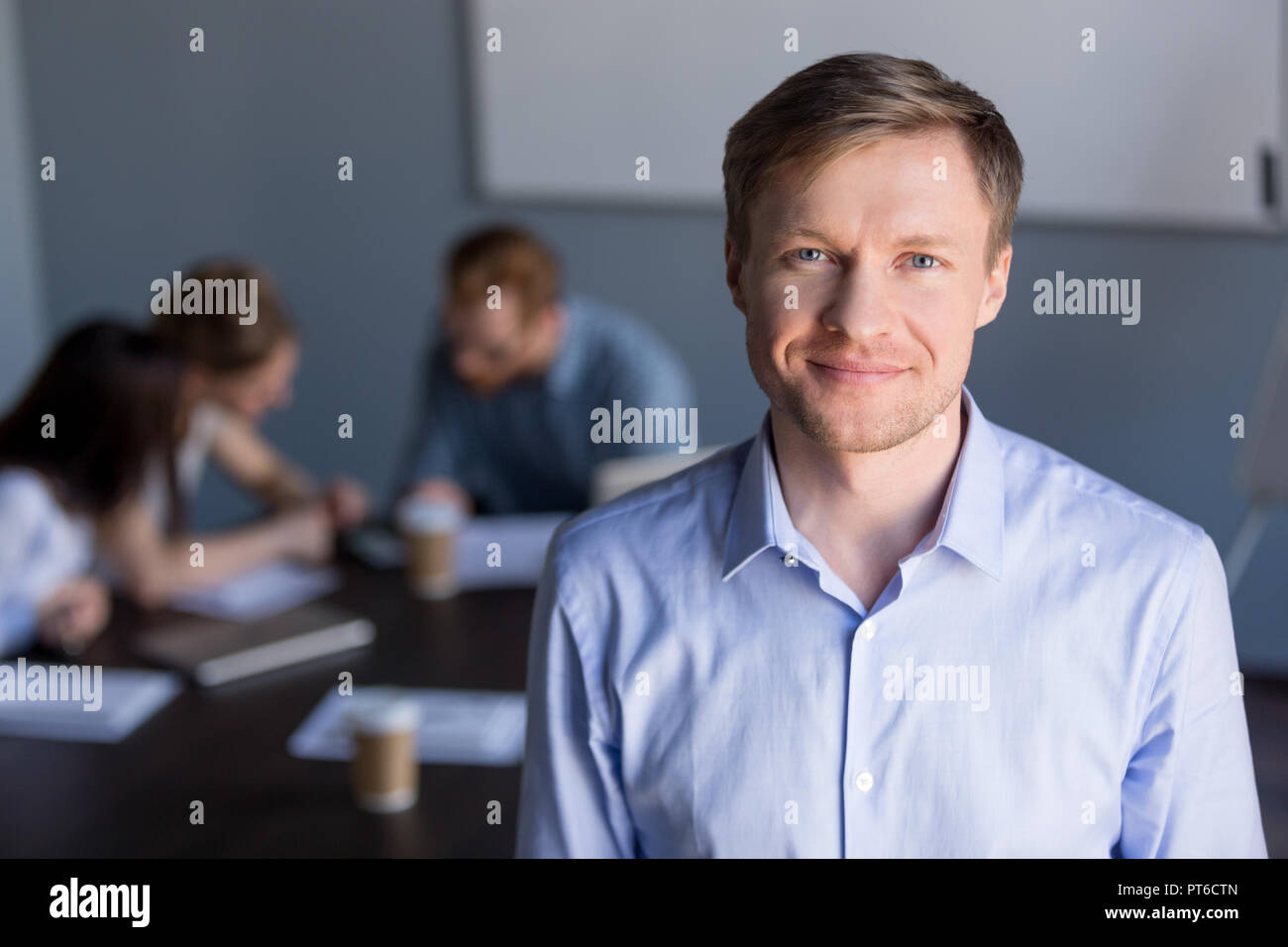 Portrait of smiling successful company ceo with team at backgrou Stock ...