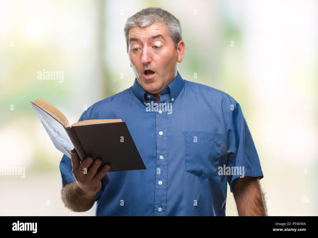 Handsome senior teacher man reading a book over isolated background ...