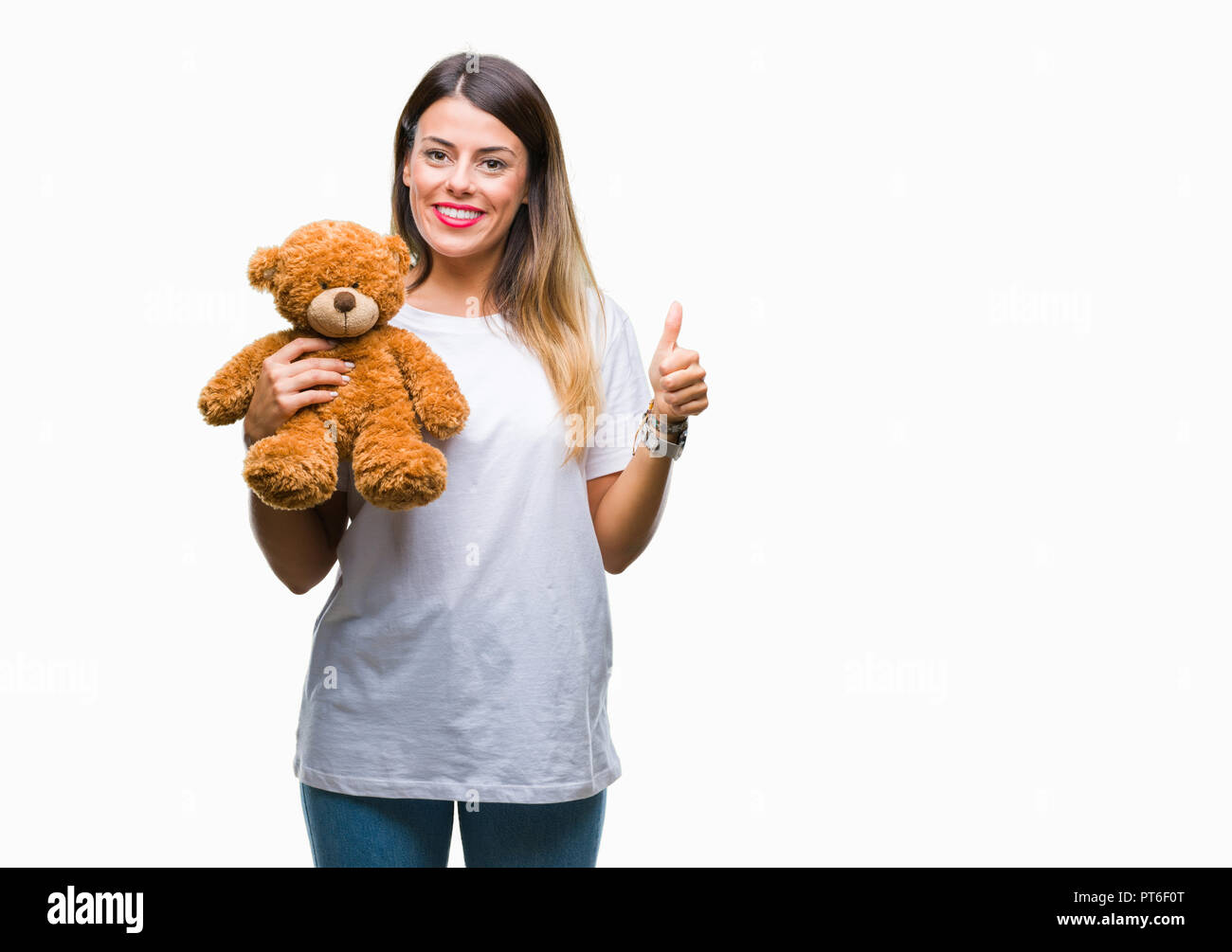 Young beautiful woman holding teddy bear plush over isolated background ...