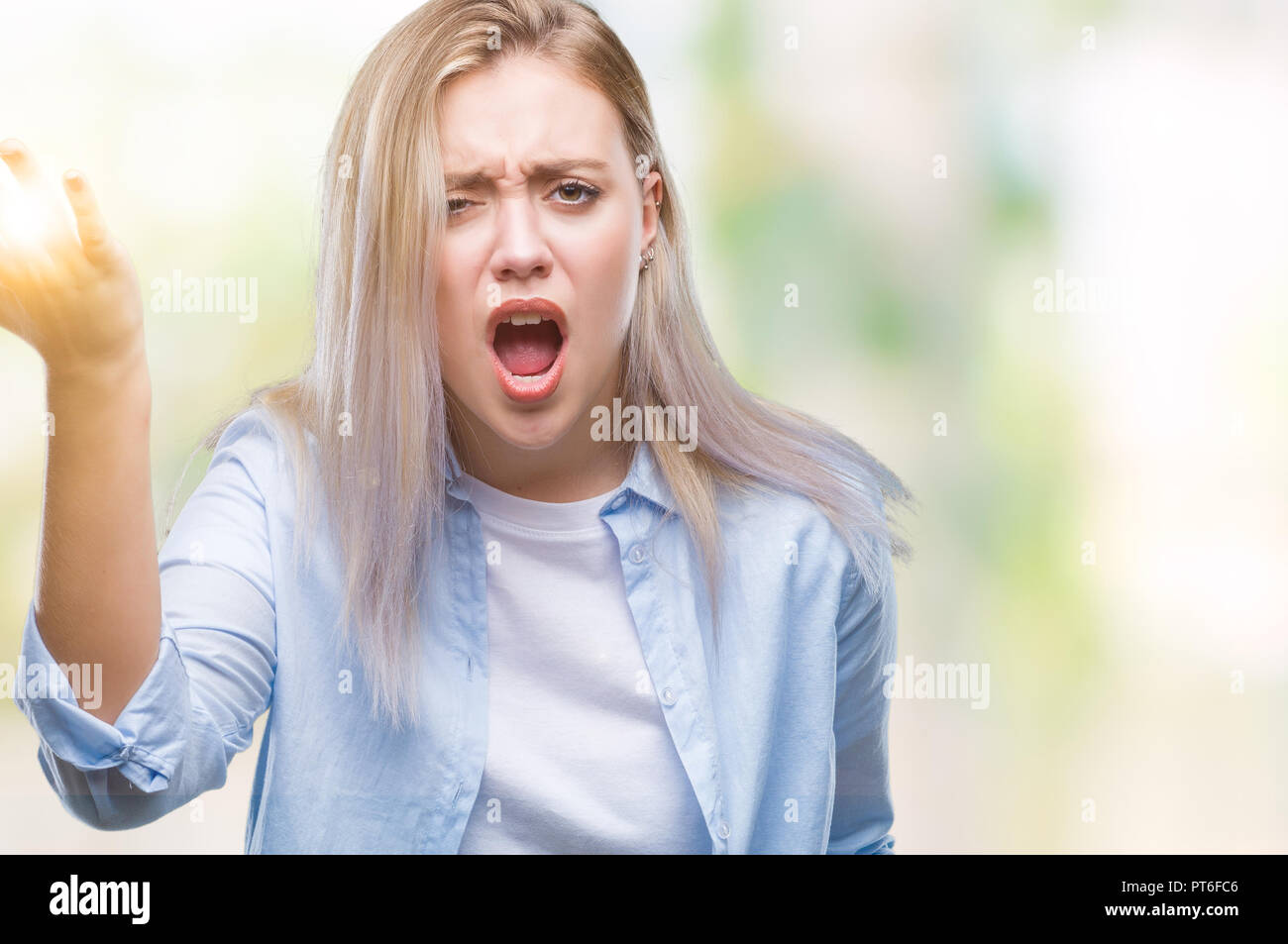 Young blonde woman over isolated background angry and mad raising fist ...