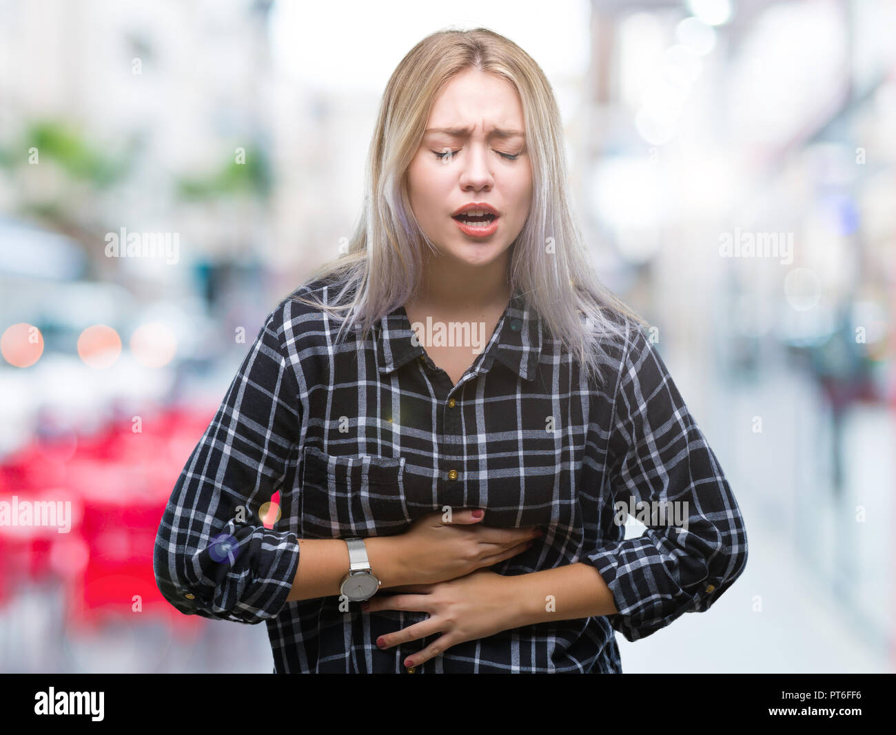 Young blonde woman over isolated background with hand on stomach ...