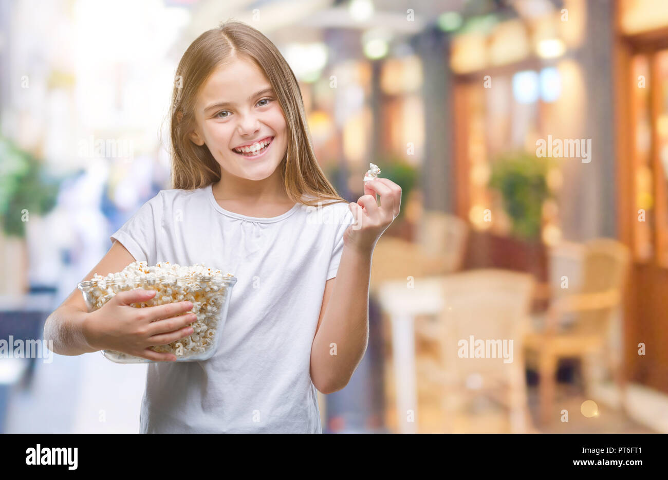 Young beautiful girl eating popcorn snack isolated background with a ...