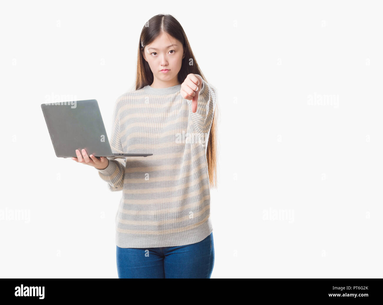 Young Chinese woman over isolated background using computer laptop with ...