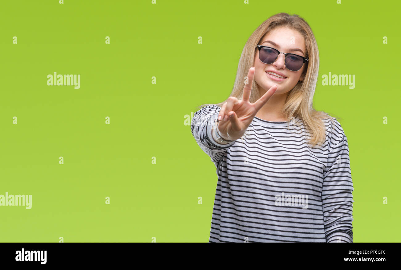 Young caucasian woman wearing sunglasses over isolated background ...