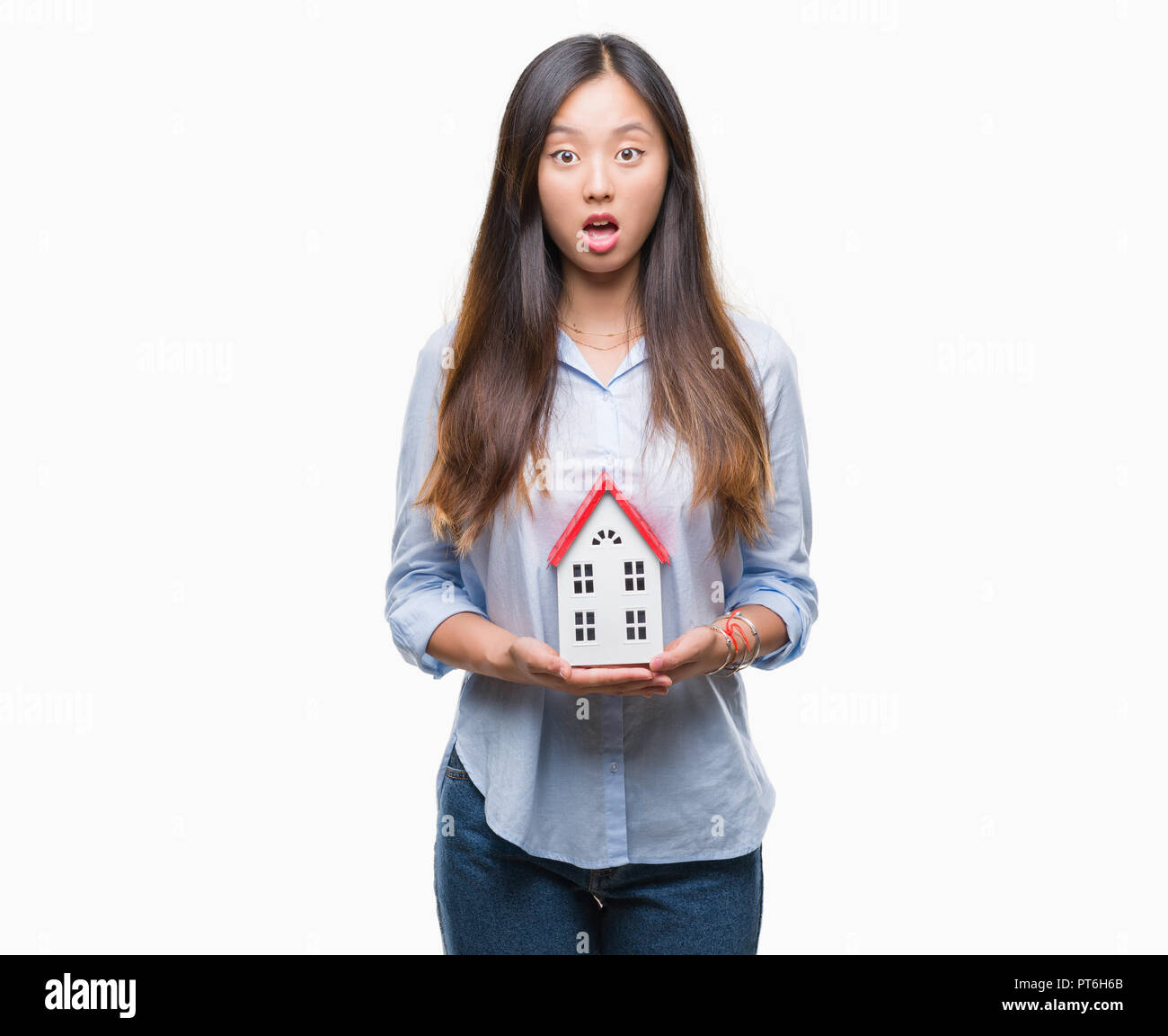 Young asian woman real state agent holding house isolated background ...