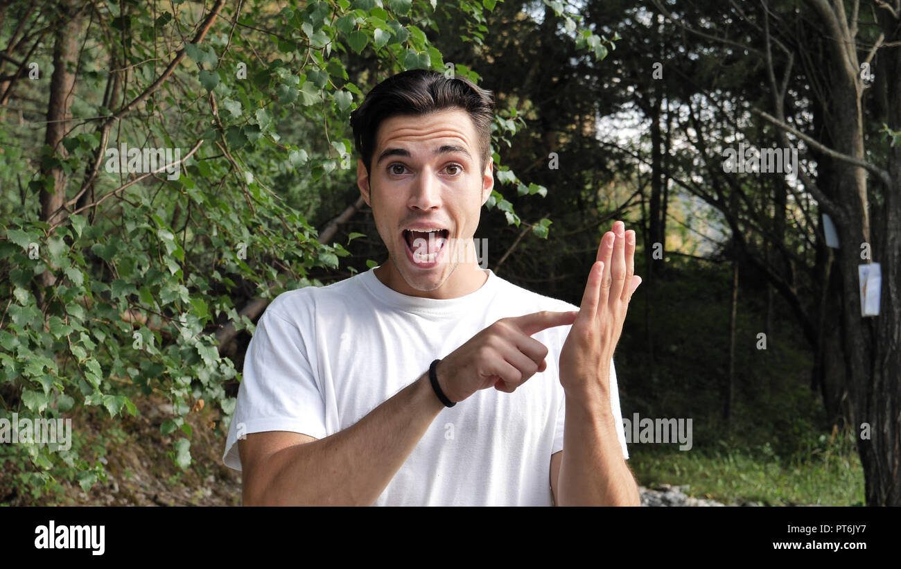 Young man doing Text Me sign, in nature Stock Photo - Alamy