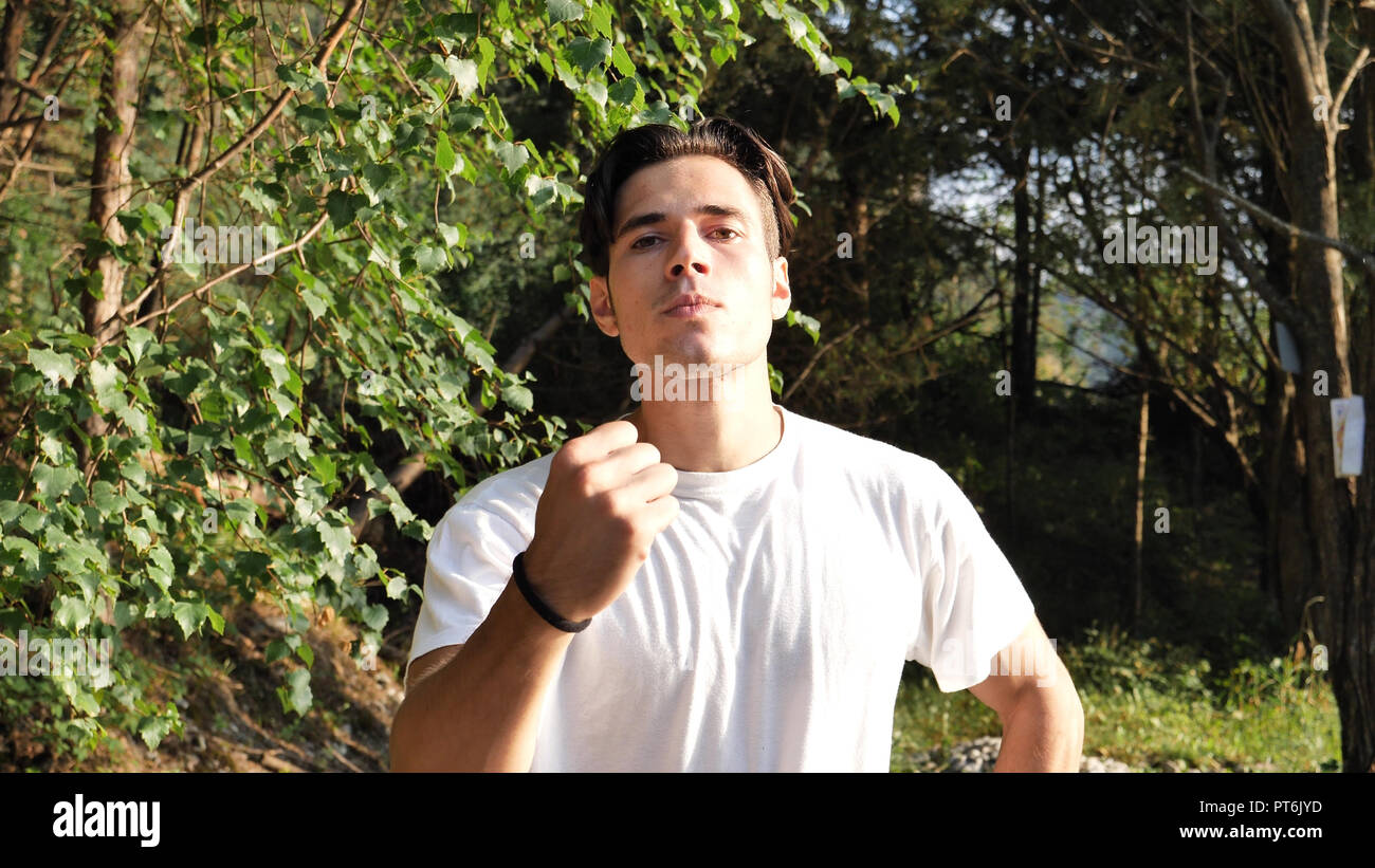 Young angry man in nature, menacing with fist Stock Photo - Alamy