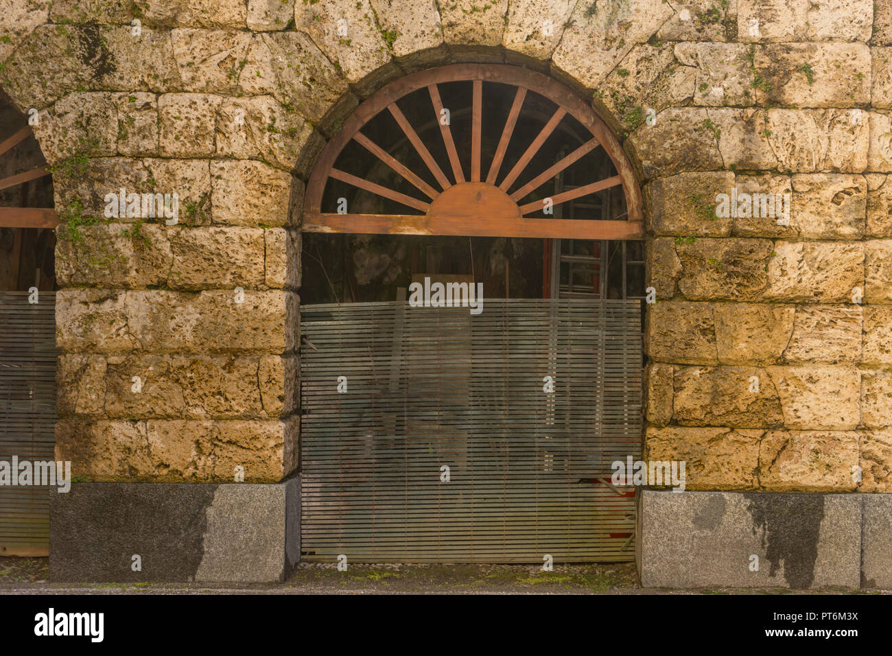 Italy, Bellagio, Lake Como, a rustic gate in front of a brick building ...