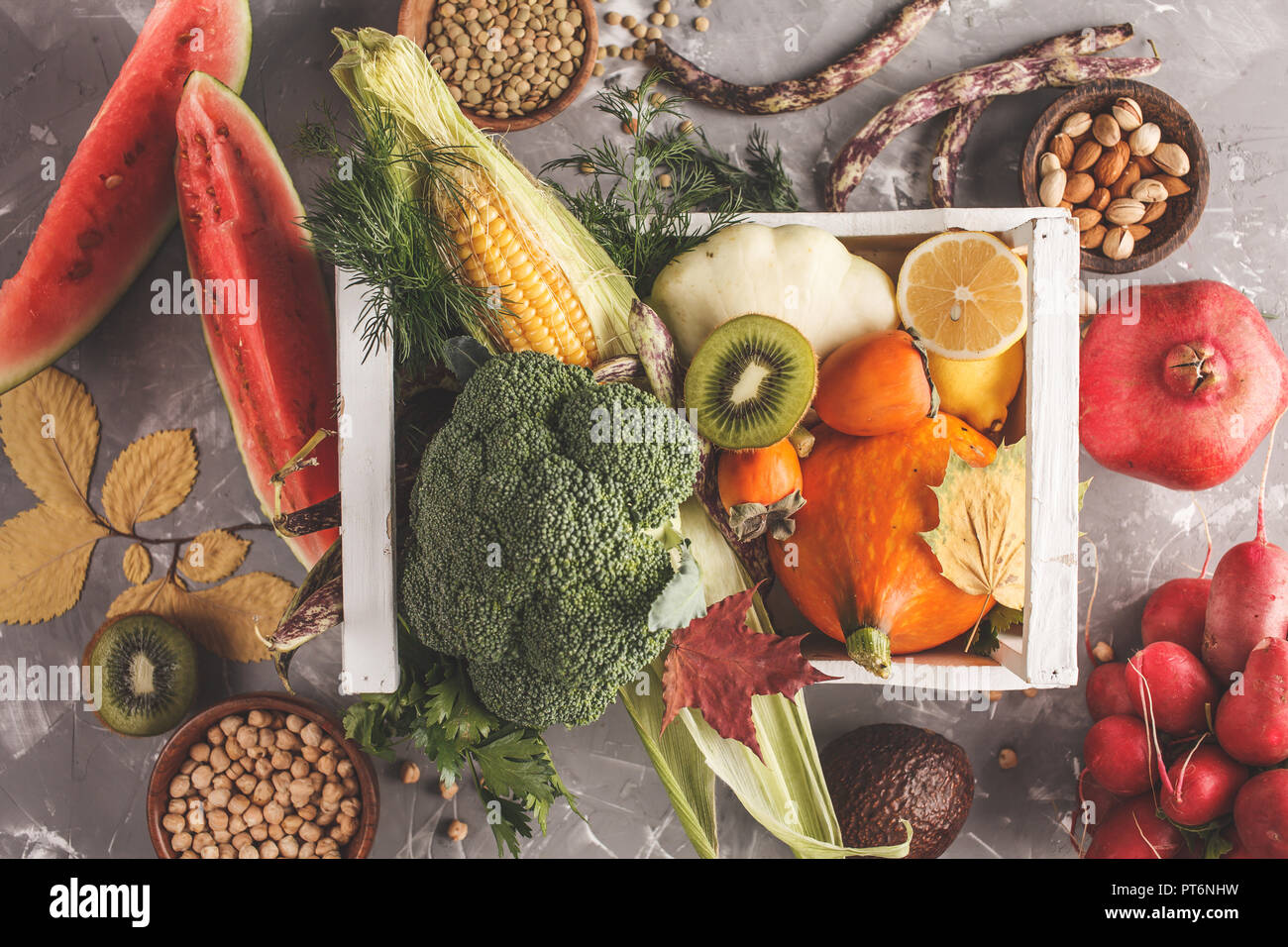 Autumn harvest food in a wooden box. Fruits, vegetables and cereals ...