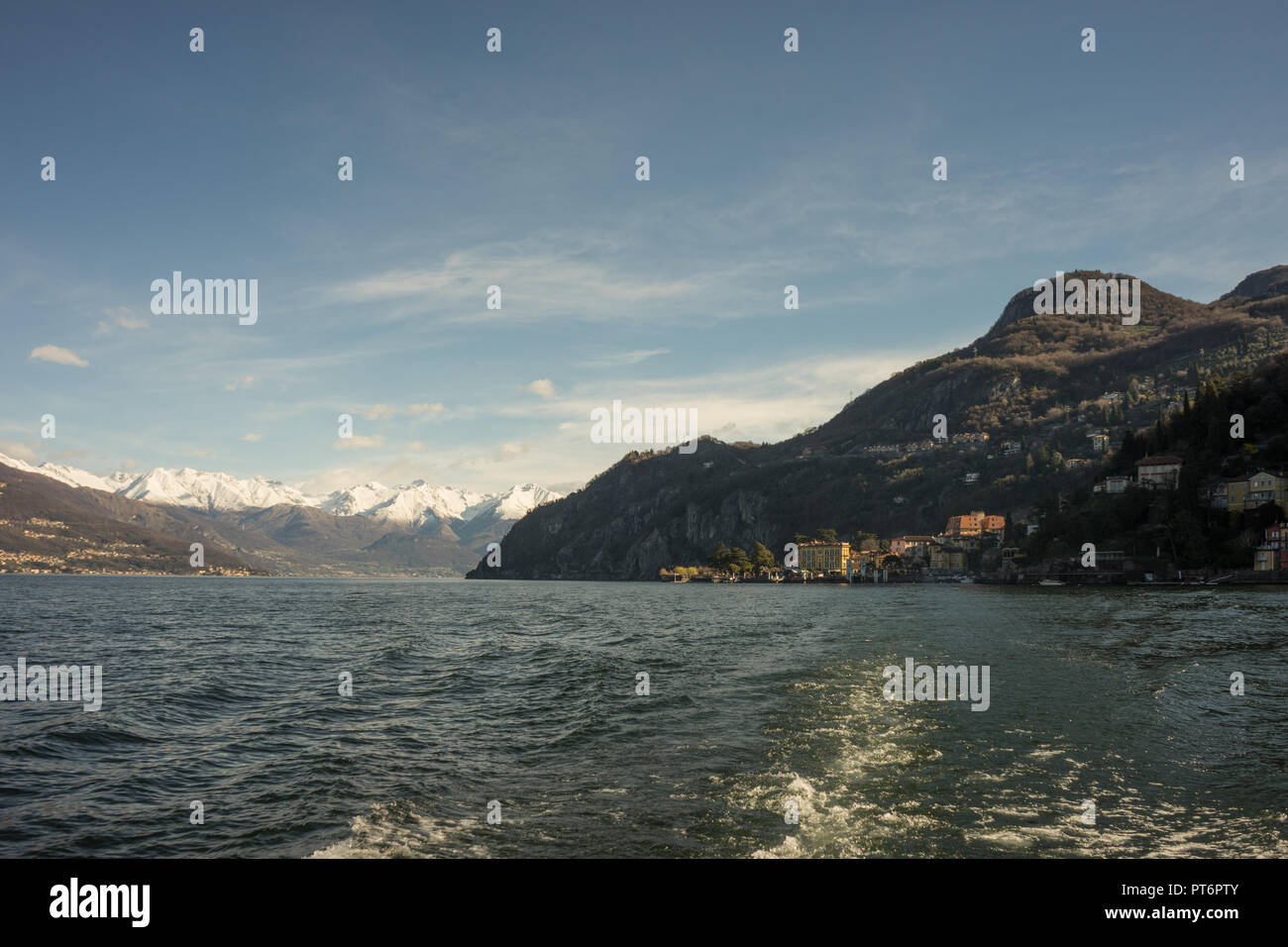 Italy, Bellagio, Lake Como, a large body of water with a snow alps in ...