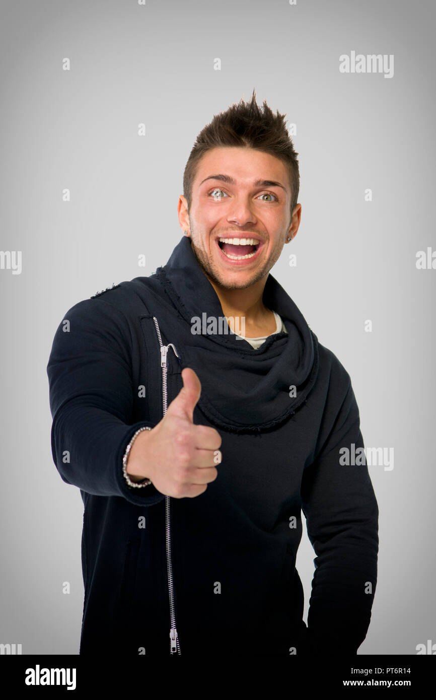 Attractive happy young man smiling, doing thumb up sign Stock Photo - Alamy