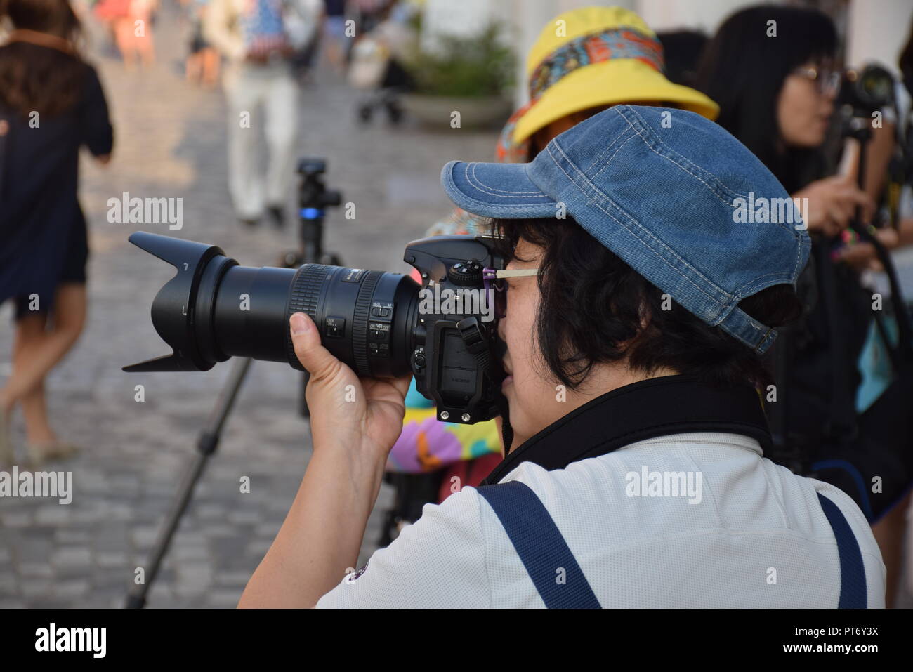 Chinese woman taking photos with her cameras on Tsim Sha Tsui promenade ...