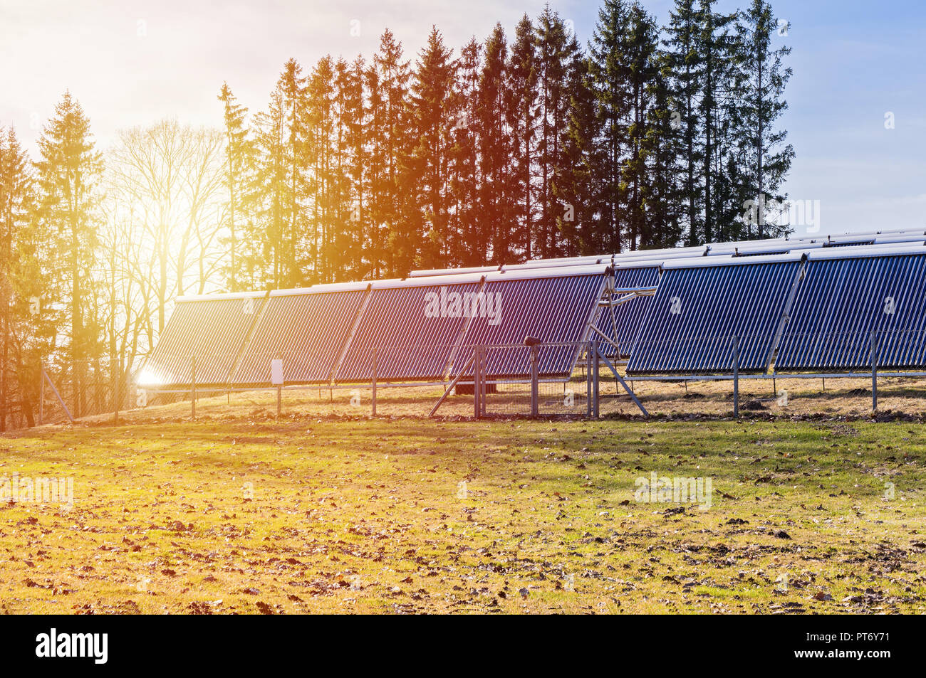 Solar panels on field in rays of sunset. Renewable solar energy concept ...