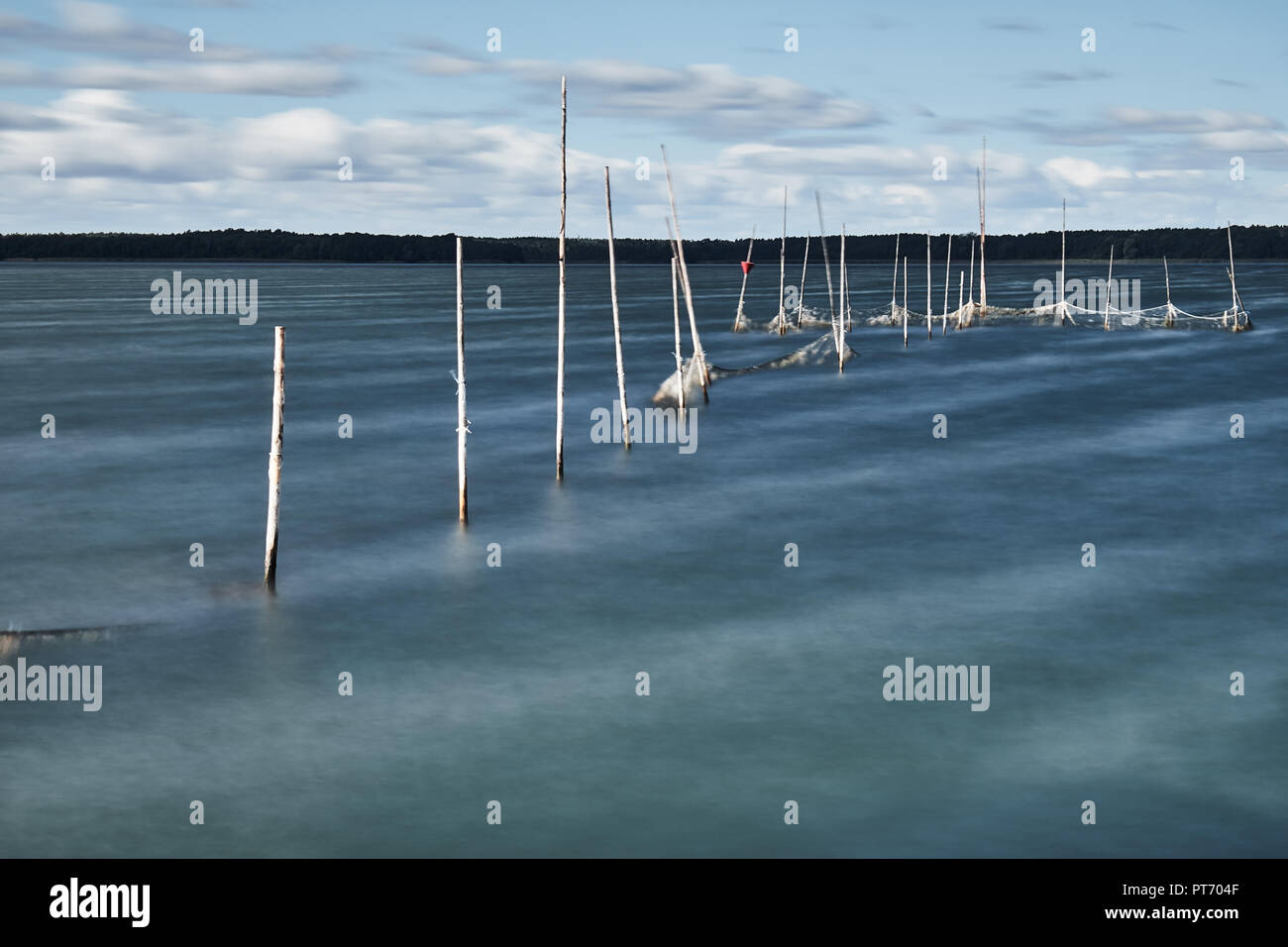 Long exposure of a lakes shore on a stormy day, creating a blurry water ...