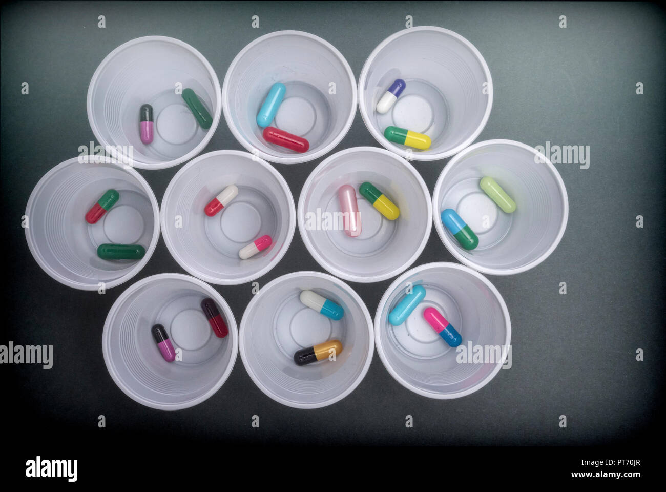 Glasses of plastic white with daily dose of medication, conceptual ...