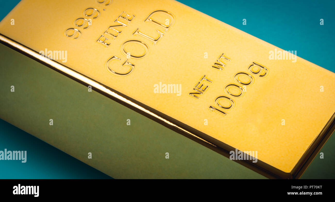 gold bar closeup on blue background Stock Photo - Alamy
