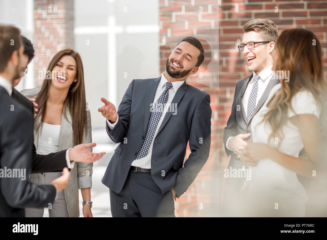 smiling staff discussing something in the office hallway Stock Photo ...